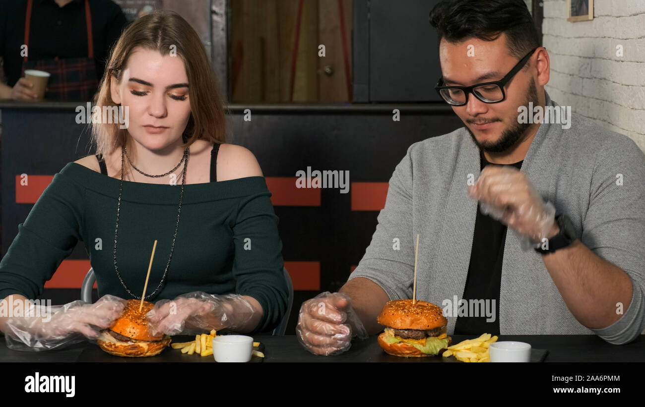 Couple eating burgers in burger bar hi-res stock photography and images ...