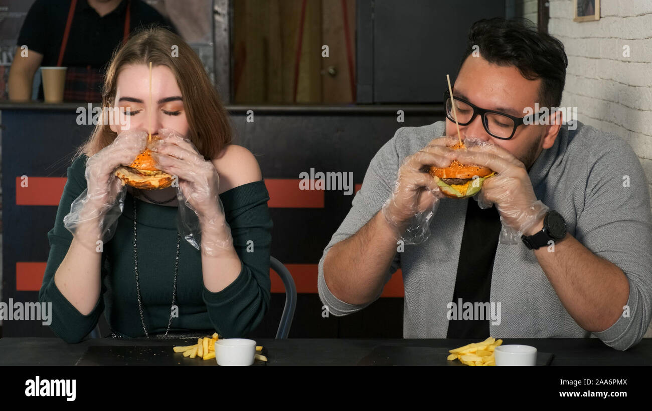Couple eating burgers in burger bar hi-res stock photography and images ...