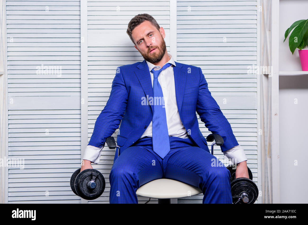 should work for success. challenging himself. businessman hold dumbbell ...