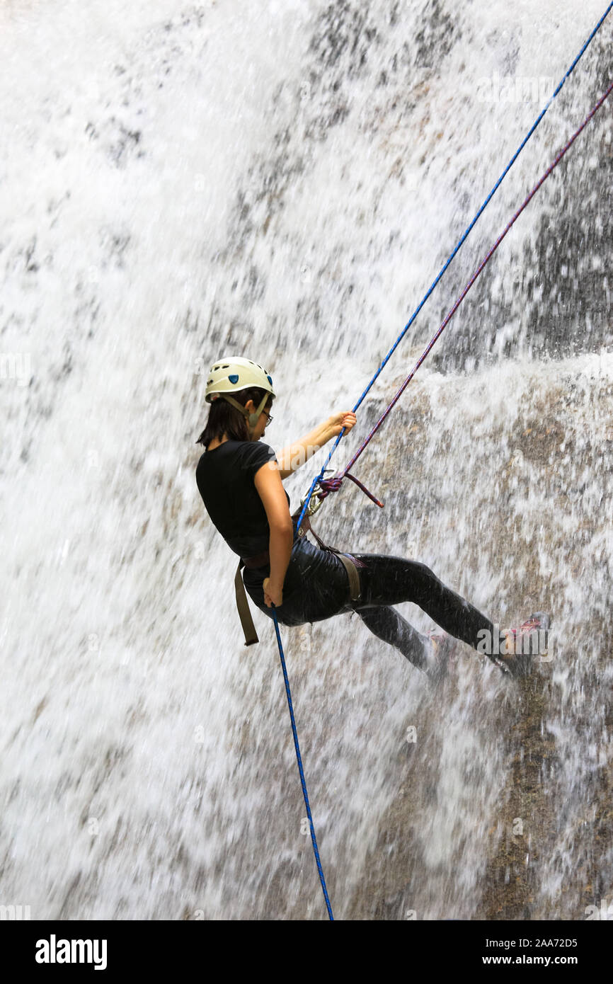 Back view of a person abseiling down a waterfall in Gopeng Perak ...