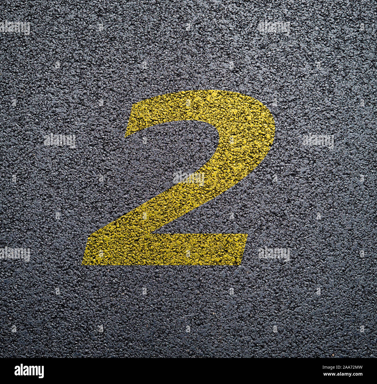 Yellow numbers and signs on the asphalt Stock Photo - Alamy
