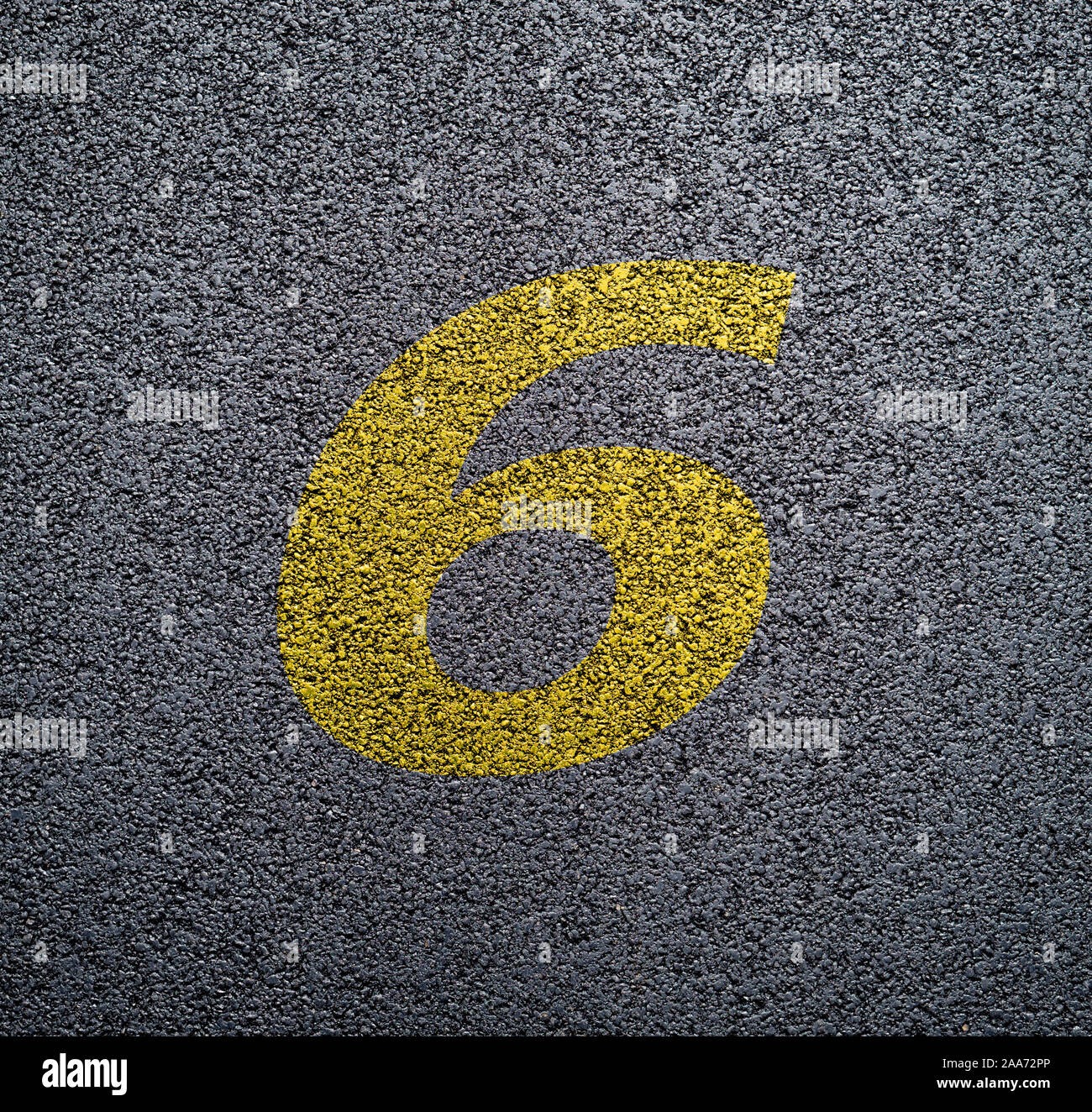 Yellow numbers and signs on the asphalt Stock Photo - Alamy
