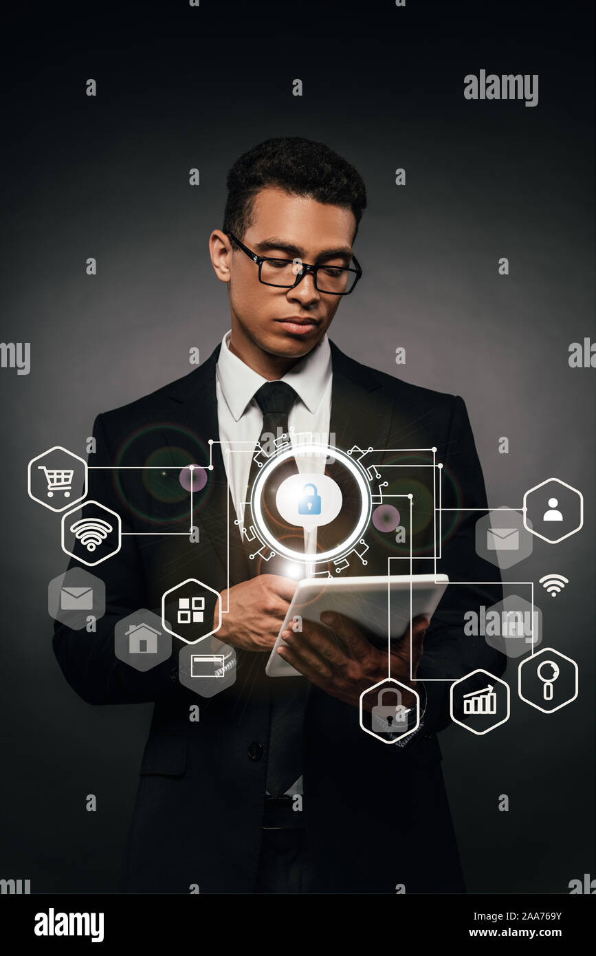 african american businessman in glasses using digital tablet on dark ...