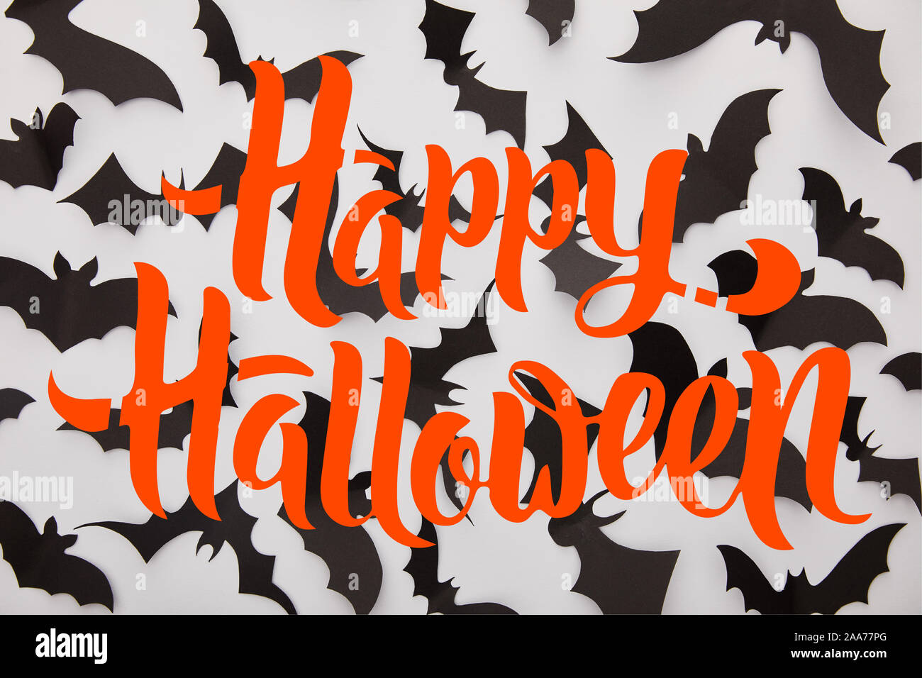 top view of paper black bats on white background with red happy ...