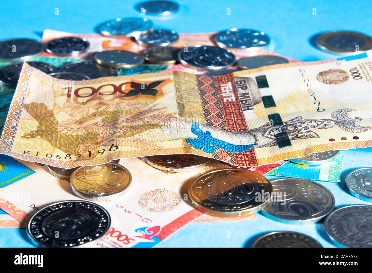 Tenge on a blue background with coins. Tenge banknotes. Coins Of ...