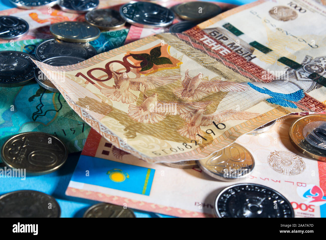 Tenge on a blue background with coins. Tenge banknotes. Coins Of ...