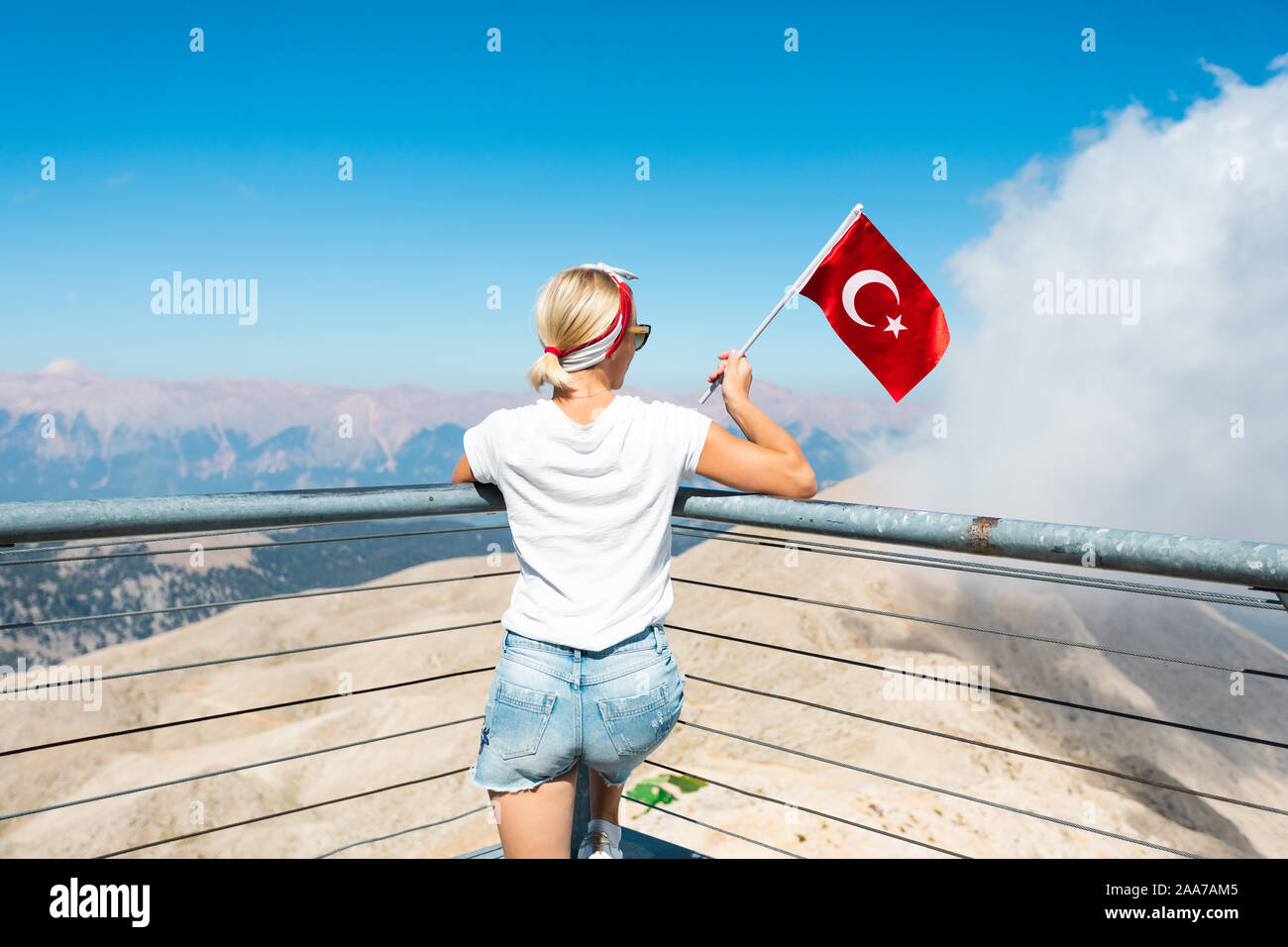 Young woman tourist stands on a viewing platform of Tahtali Mountain in ...