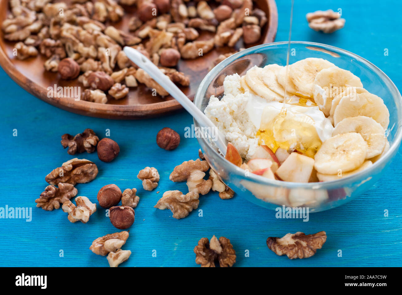 Breakfast, cottage cheese, sour cream banana nuts on a blue wooden ...