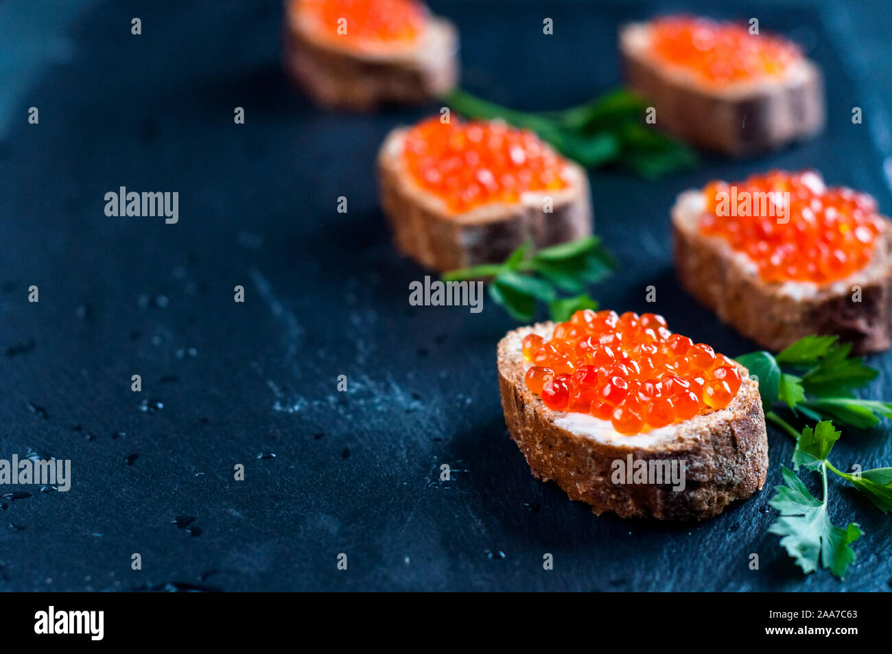 Red caviar on slate background. Selective focus Stock Photo - Alamy