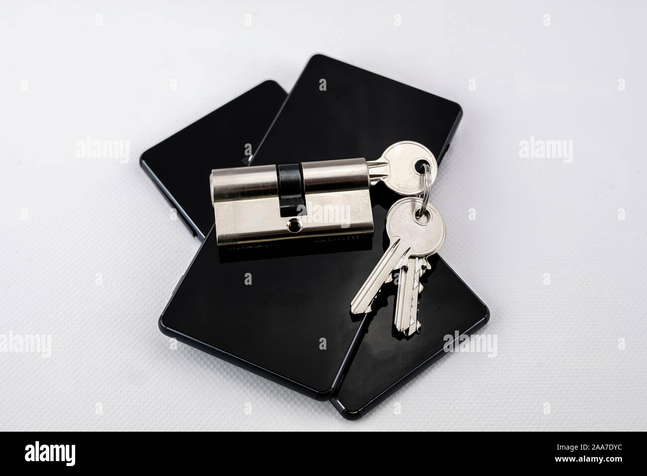 keychain with keys inserted in a lock on two black mobile phones on ...