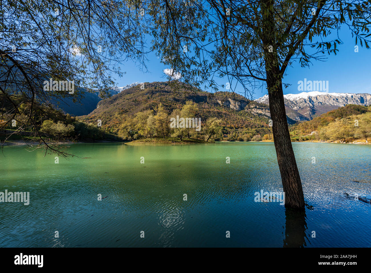 Lago di Tenno in autumn with island, small beautiful lake with ...