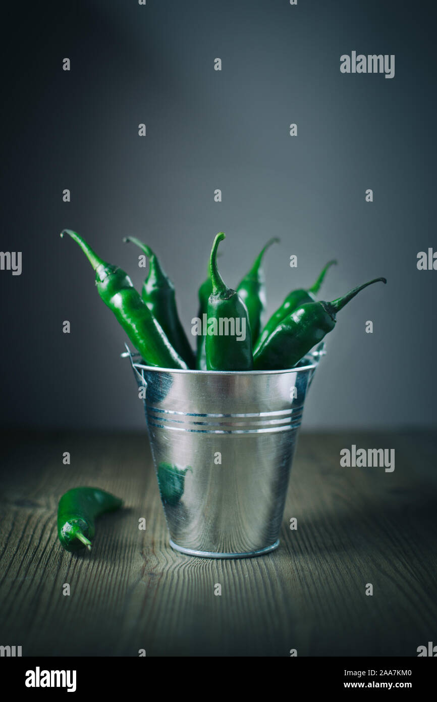 green chili pepper in a pail, low key, toned Stock Photo - Alamy