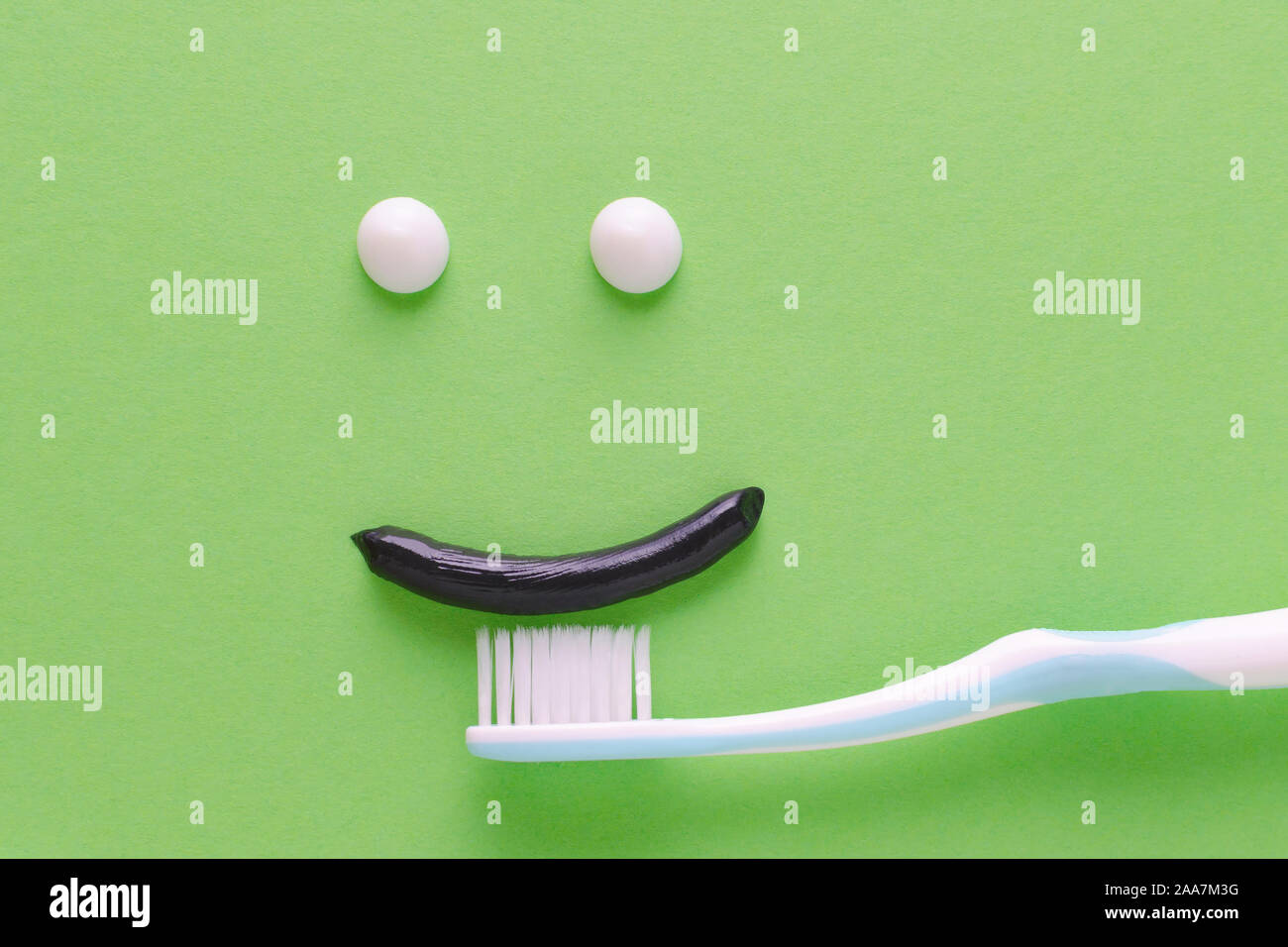 a face with smile from white and black toothpaste, teeth care concept ...