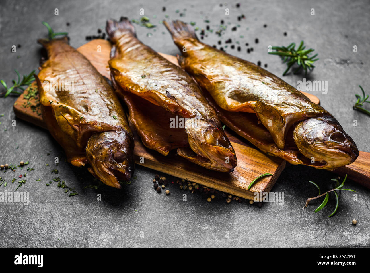 Smoked fish with spices on dark background Stock Photo - Alamy