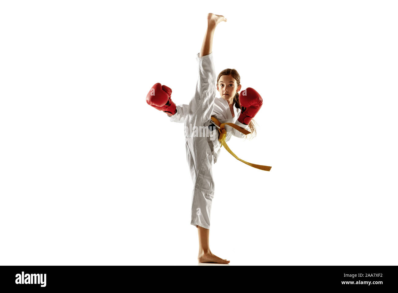 Confident junior in kimono practicing hand-to-hand combat, martial arts ...