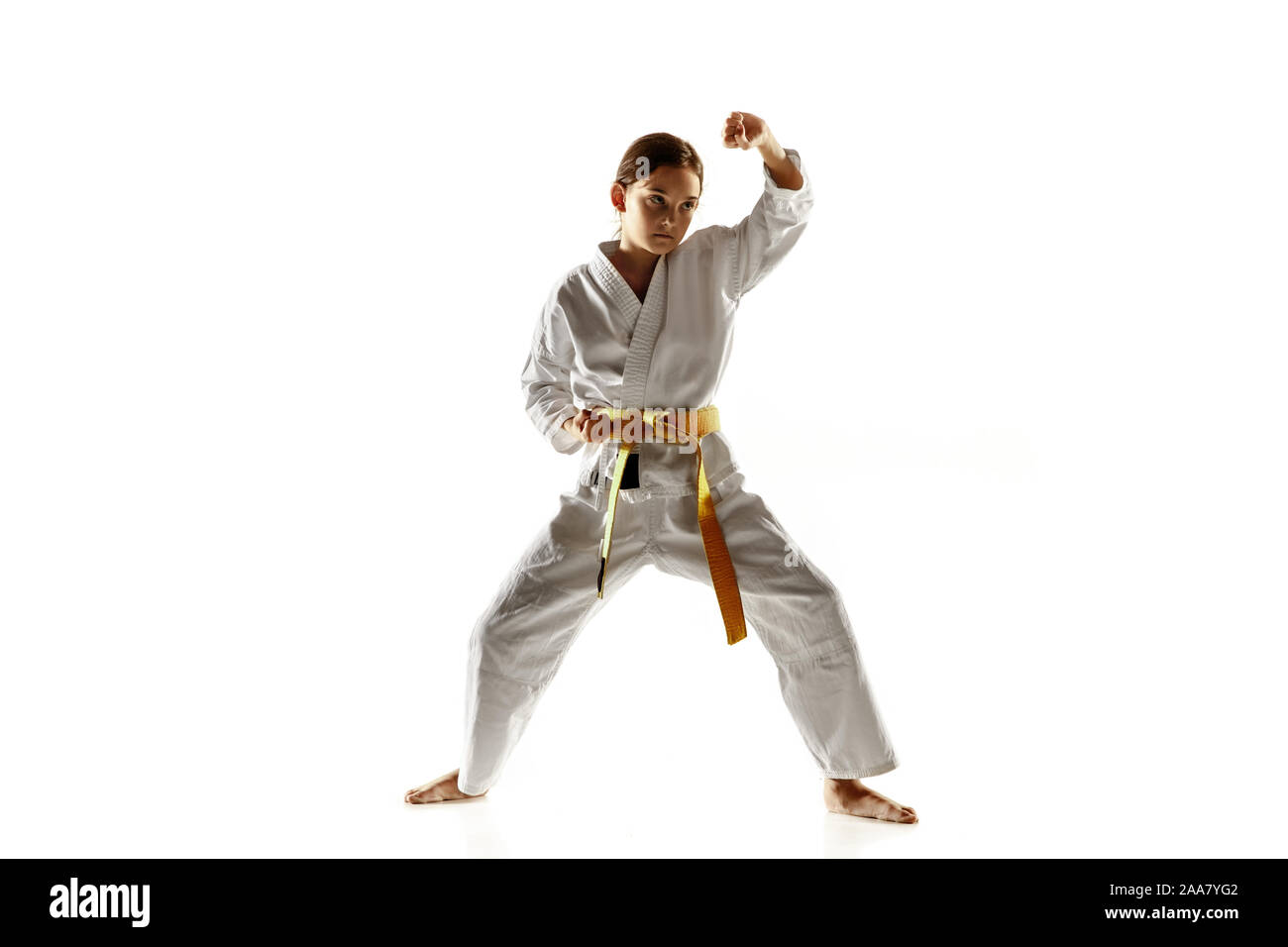 Confident junior in kimono practicing hand-to-hand combat, martial arts ...
