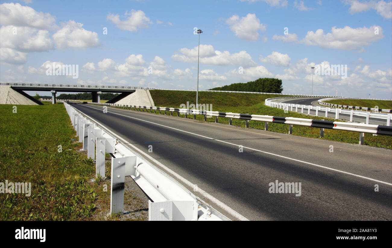 cars driving on the highway. Road junction bridge overpass crosses the ...