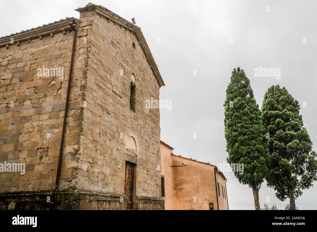 Medieval parish church facade with cypress trees in Italy Stock Photo ...