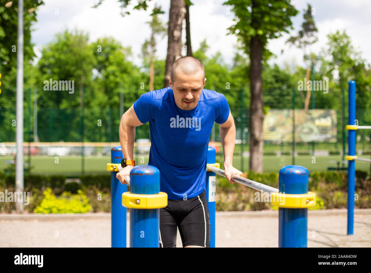 Adult man doing push up on bars at sports ground Stock Photo - Alamy
