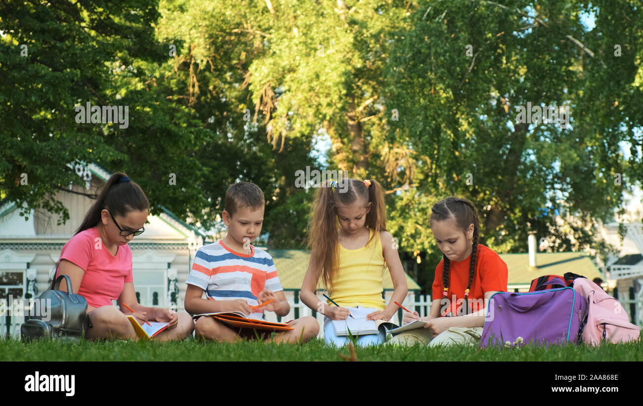Children and education, a group of schoolchildren doing homework on the ...