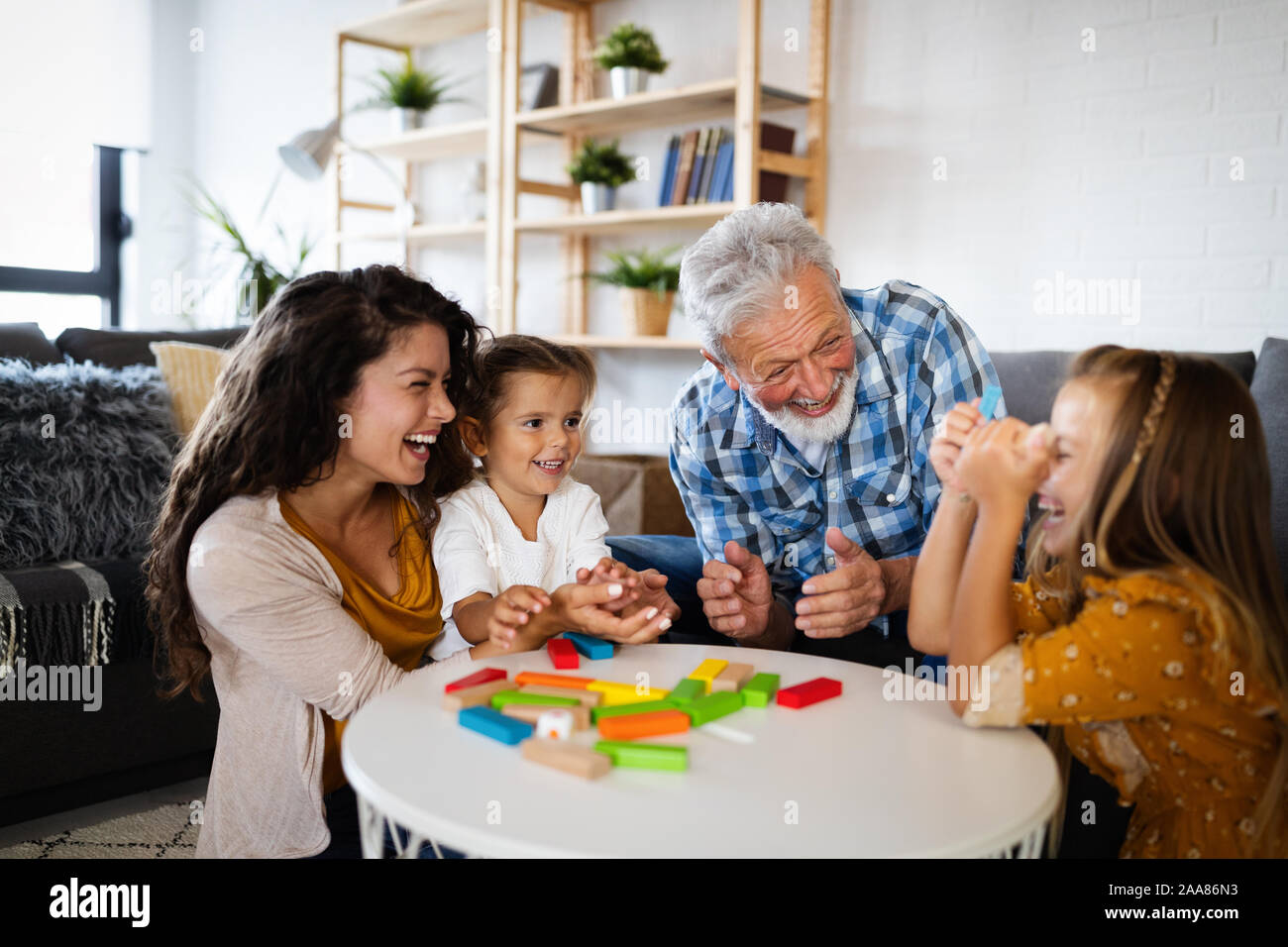 Happy family having fun time at home. Grandparent playing with children ...