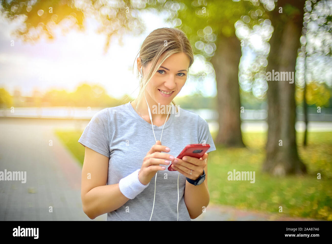 Girl athlete jogging in the evening park. Resting and talking on social ...