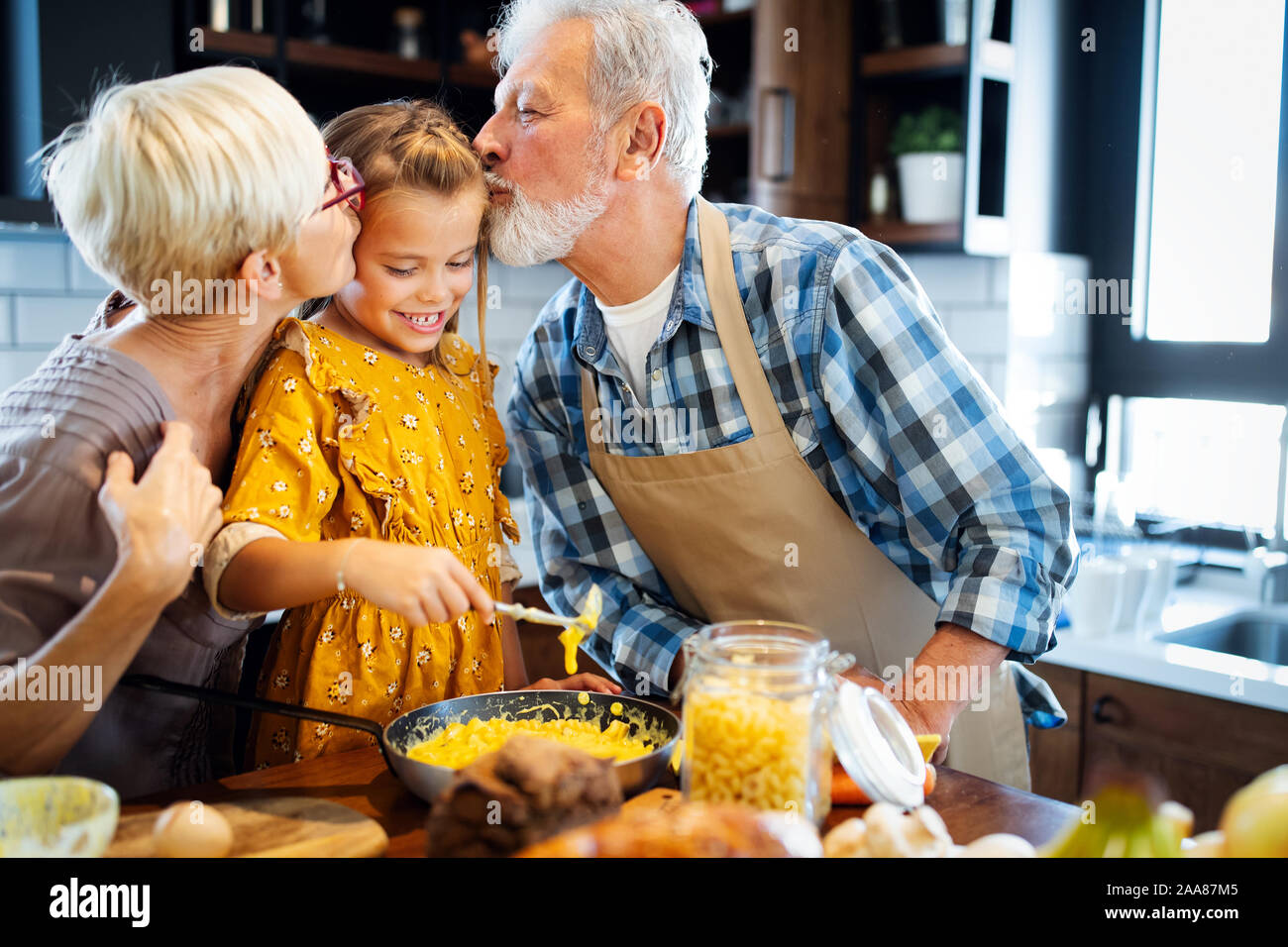 Happy grandparents with grandchildren making breakfast in kitchen Stock ...