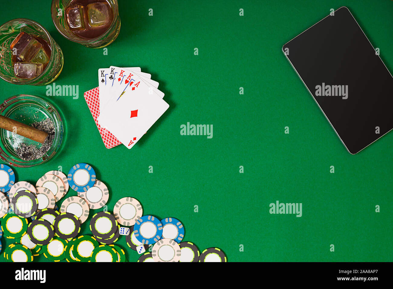 Set to playing poker with cards and chips on green background. Top view ...