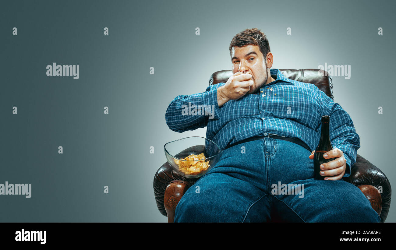Portrait of fat caucasian man wearing jeanse and whirt sitting in a ...