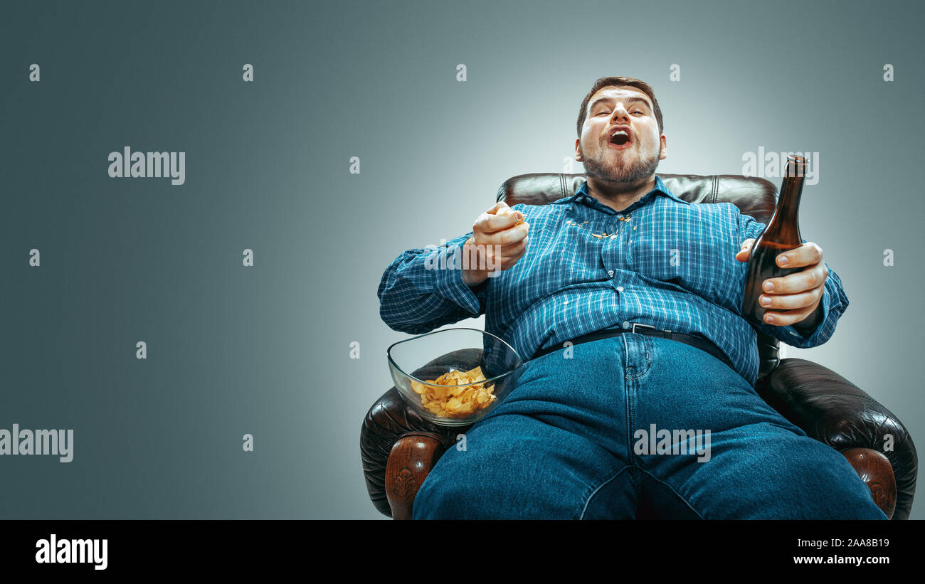 Portrait of fat caucasian man wearing jeanse and whirt sitting in a ...