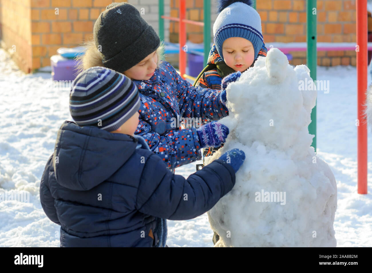 Friends make a snowman on a winter playground, children's games ...