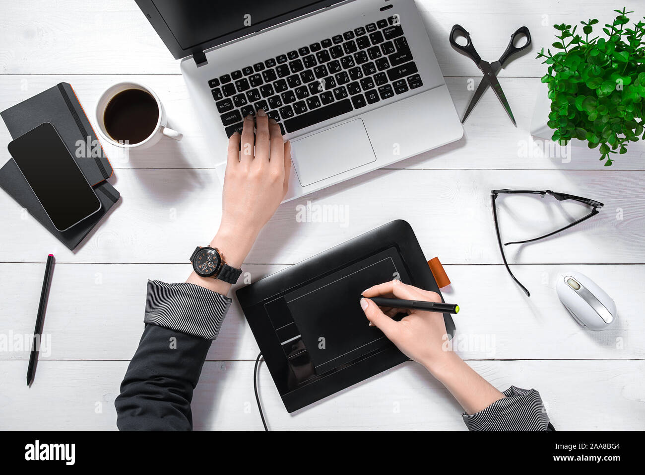 Top view of woman's hands typing on laptop keypad placed on white ...