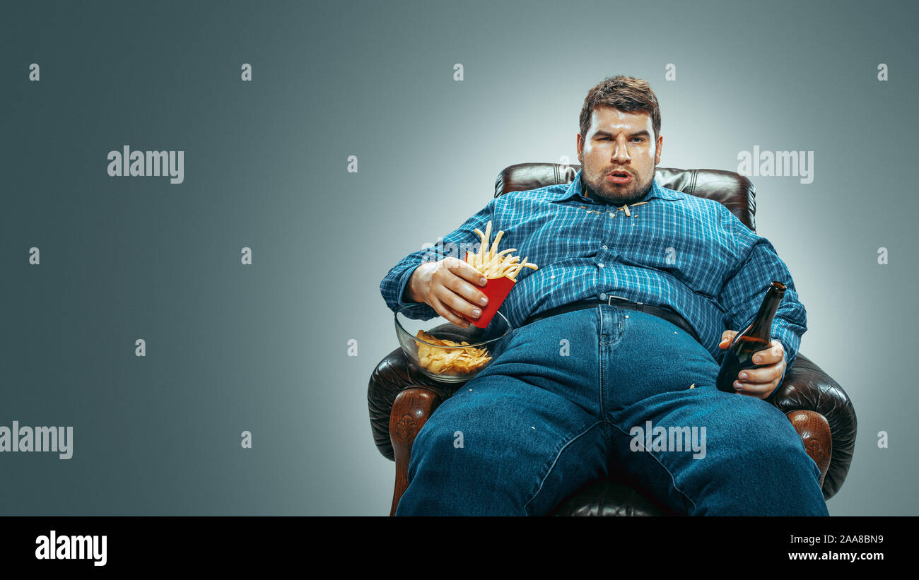 Fat man eating chips hi-res stock photography and images - Alamy