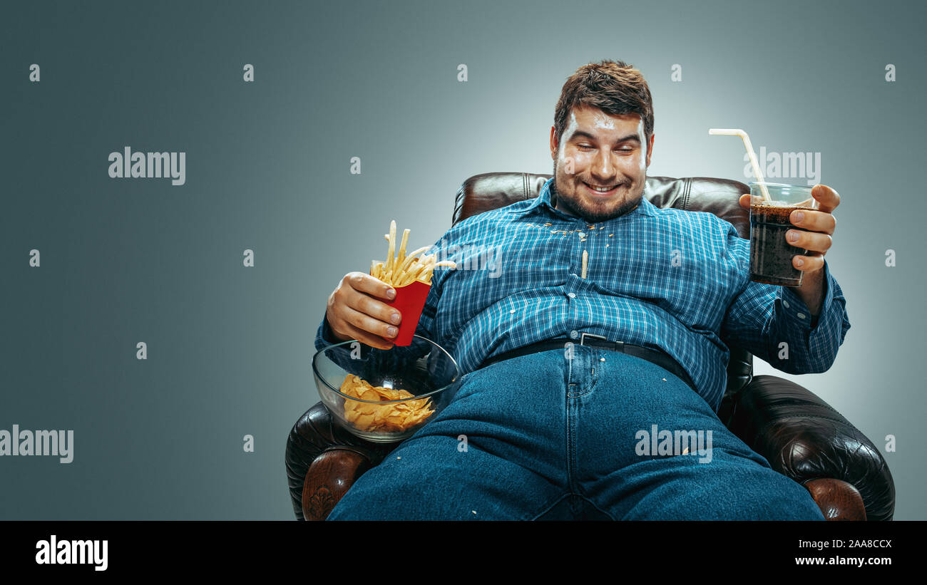 Fat man eating chips hi-res stock photography and images - Alamy