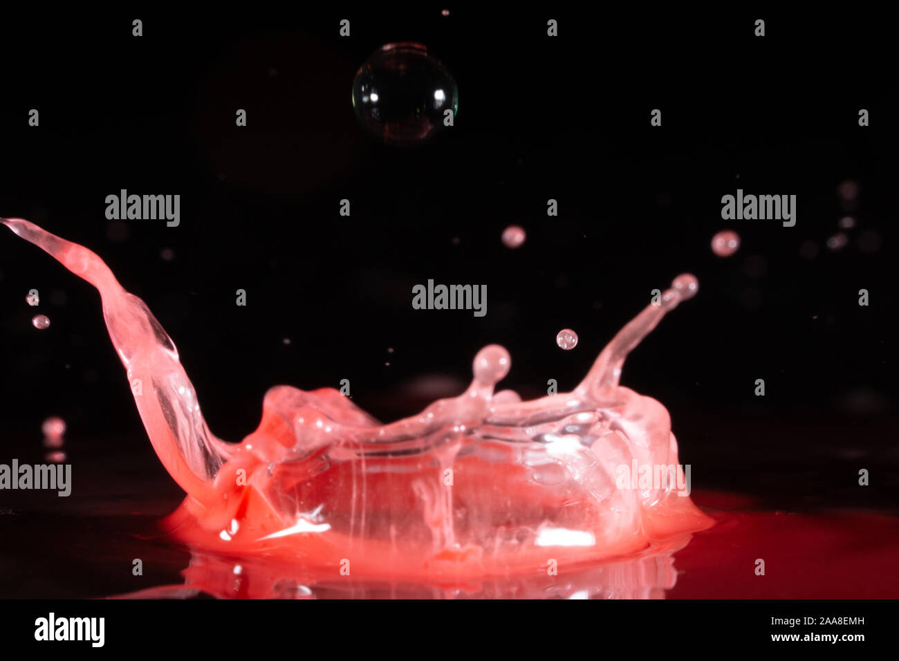 Red liquid ink splash on black background Stock Photo - Alamy