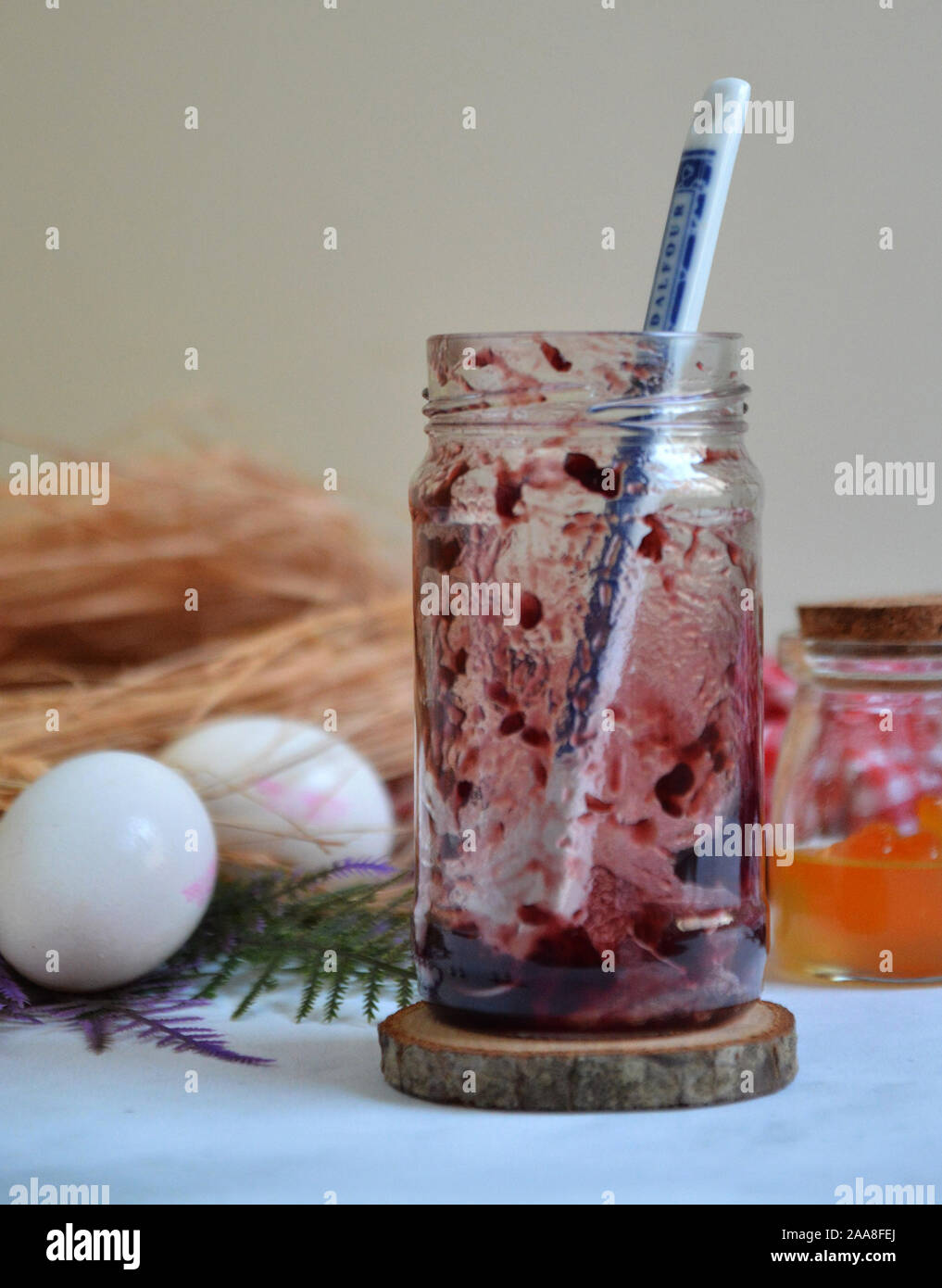 Empty strawberry jam jar with spoon. White eggs and little orange jam ...