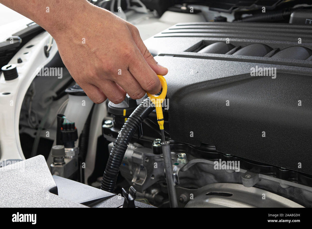 a hand pulling the lubricating oil measurement rod Stock Photo - Alamy