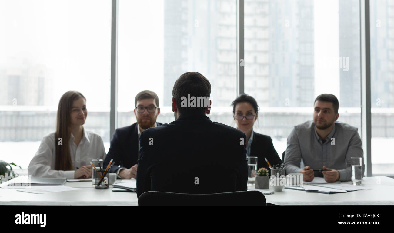 Job interview. Four members of commission talking with candidate Stock ...