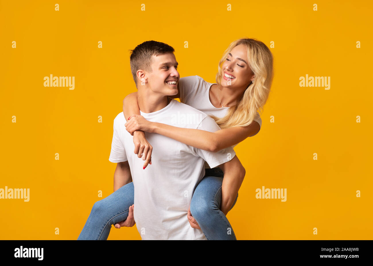 Romantic young man giving piggyback ride to his happy girlfriend Stock ...