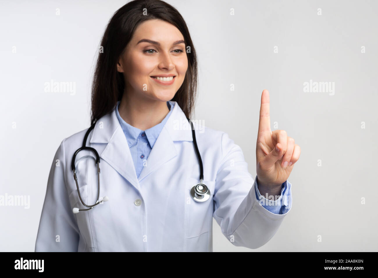 Smiling Doctor Touching Invisible Touchscreen Standing In Studio ...