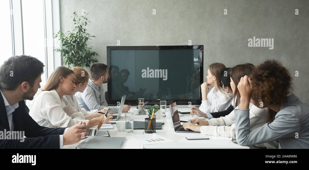 Businesspeople watching an online presentation on tv screen Stock Photo ...