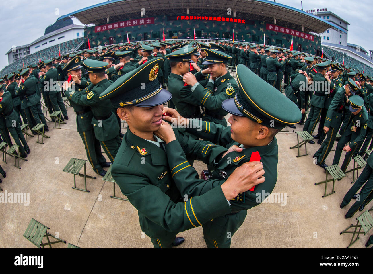 New recruits of the local armed police corp help each other in pairs to ...