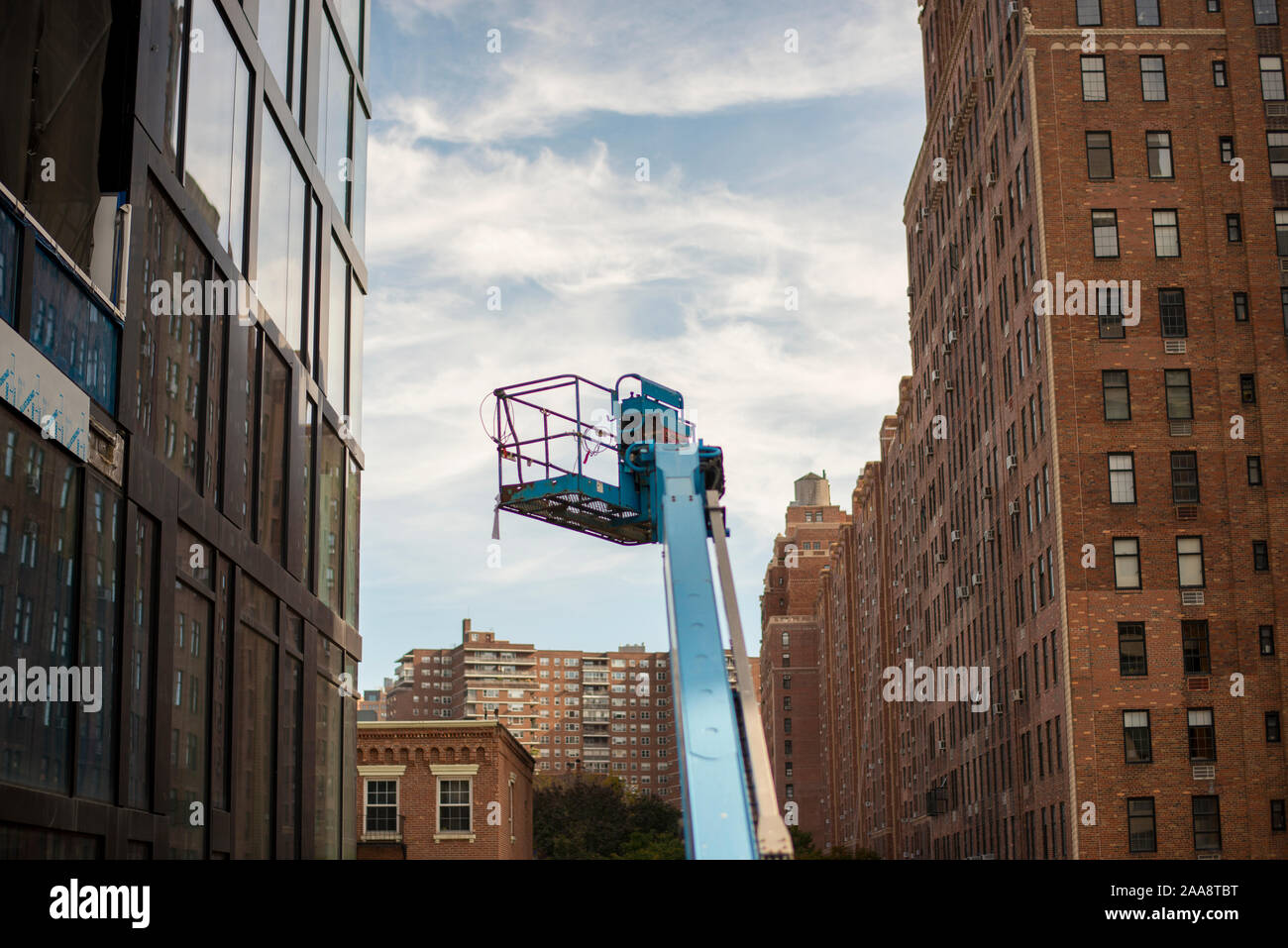 Cherry picker crane sitting idle between two high rise buldings Stock ...