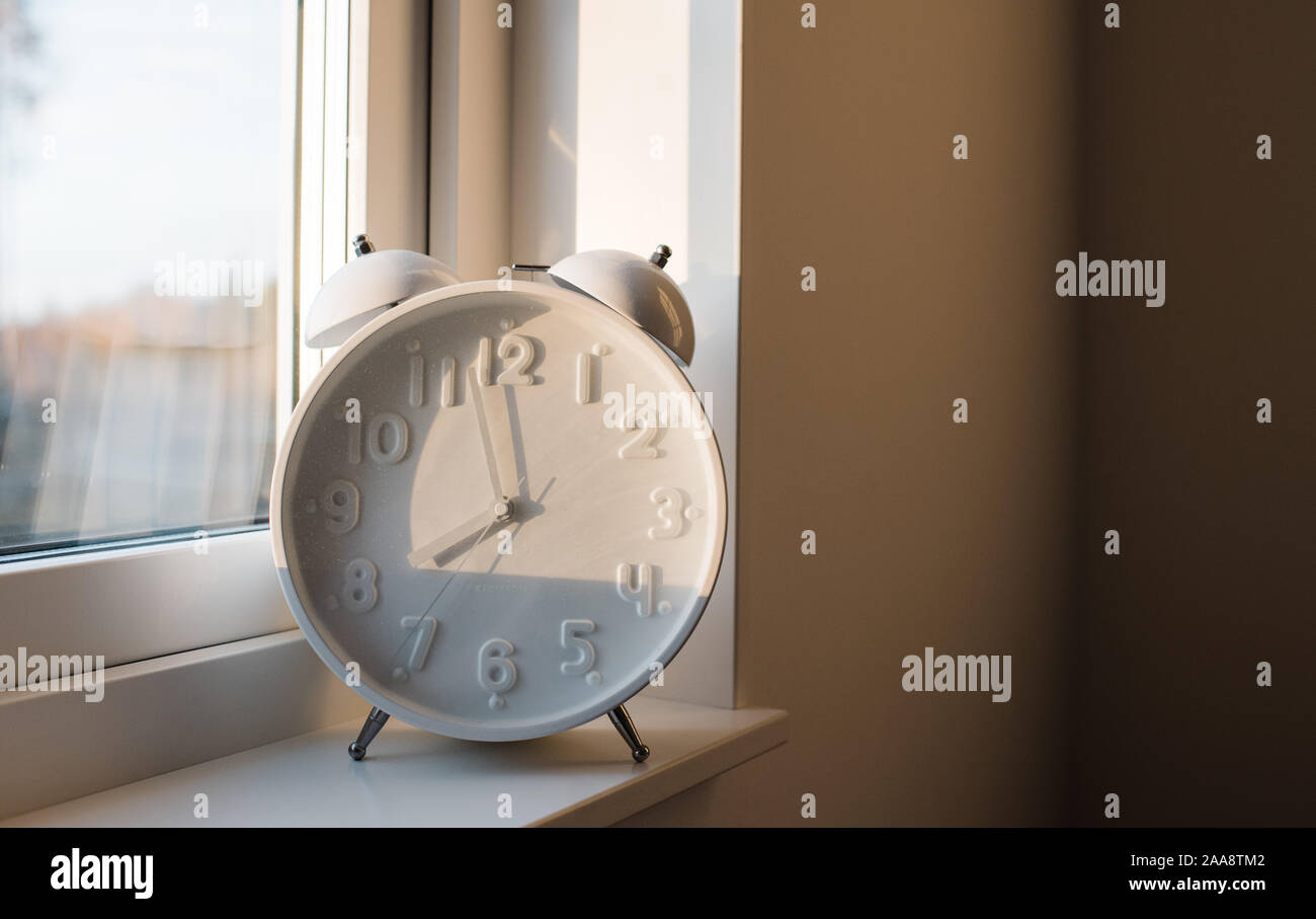 a large alarm clock sat on a window ledge of a home Stock Photo - Alamy