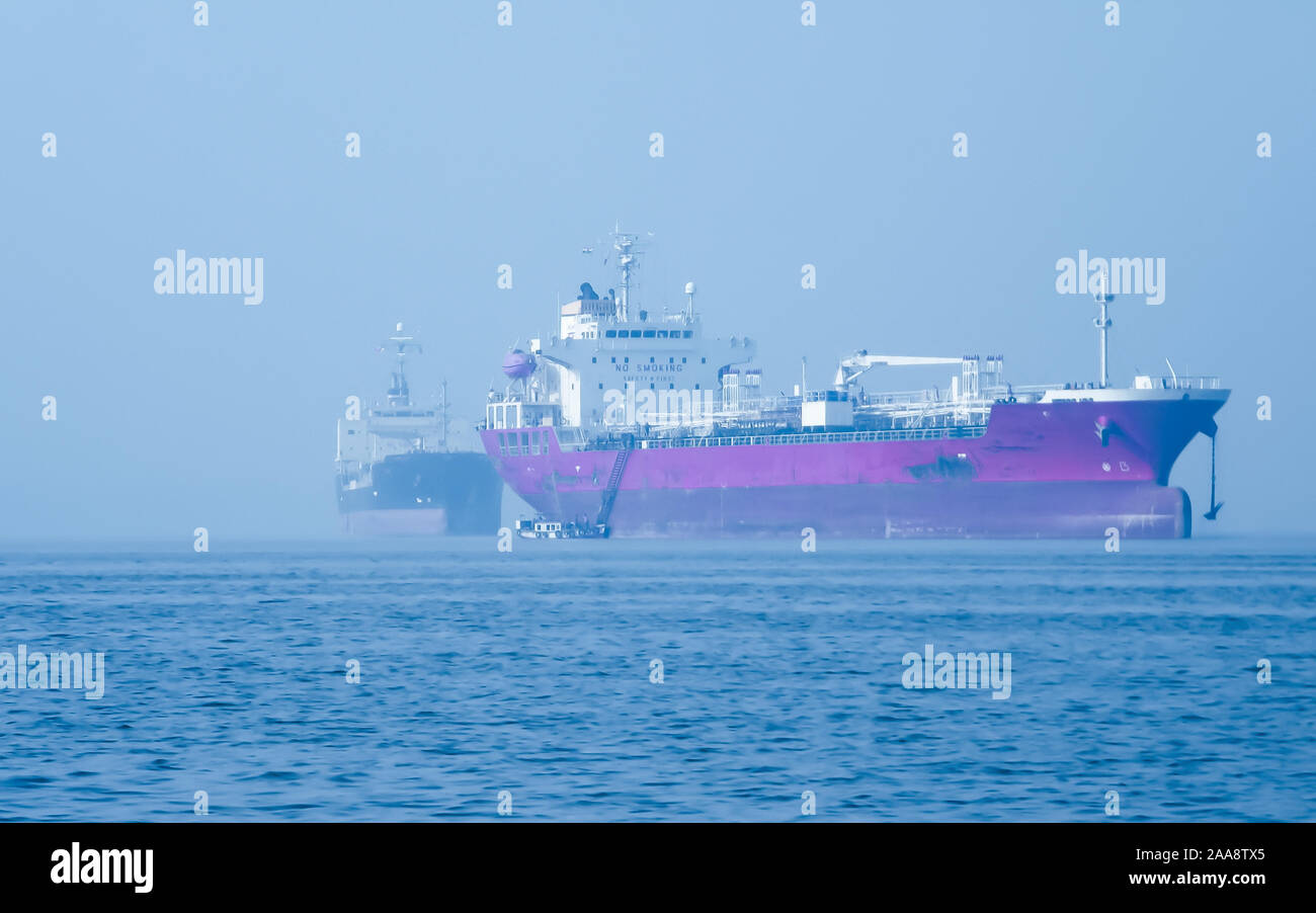 Landscape view of large and heavy rusty cargo container ship on river ...