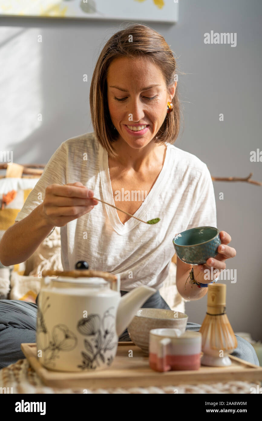 Girl making tea on her couch at home Stock Photo - Alamy