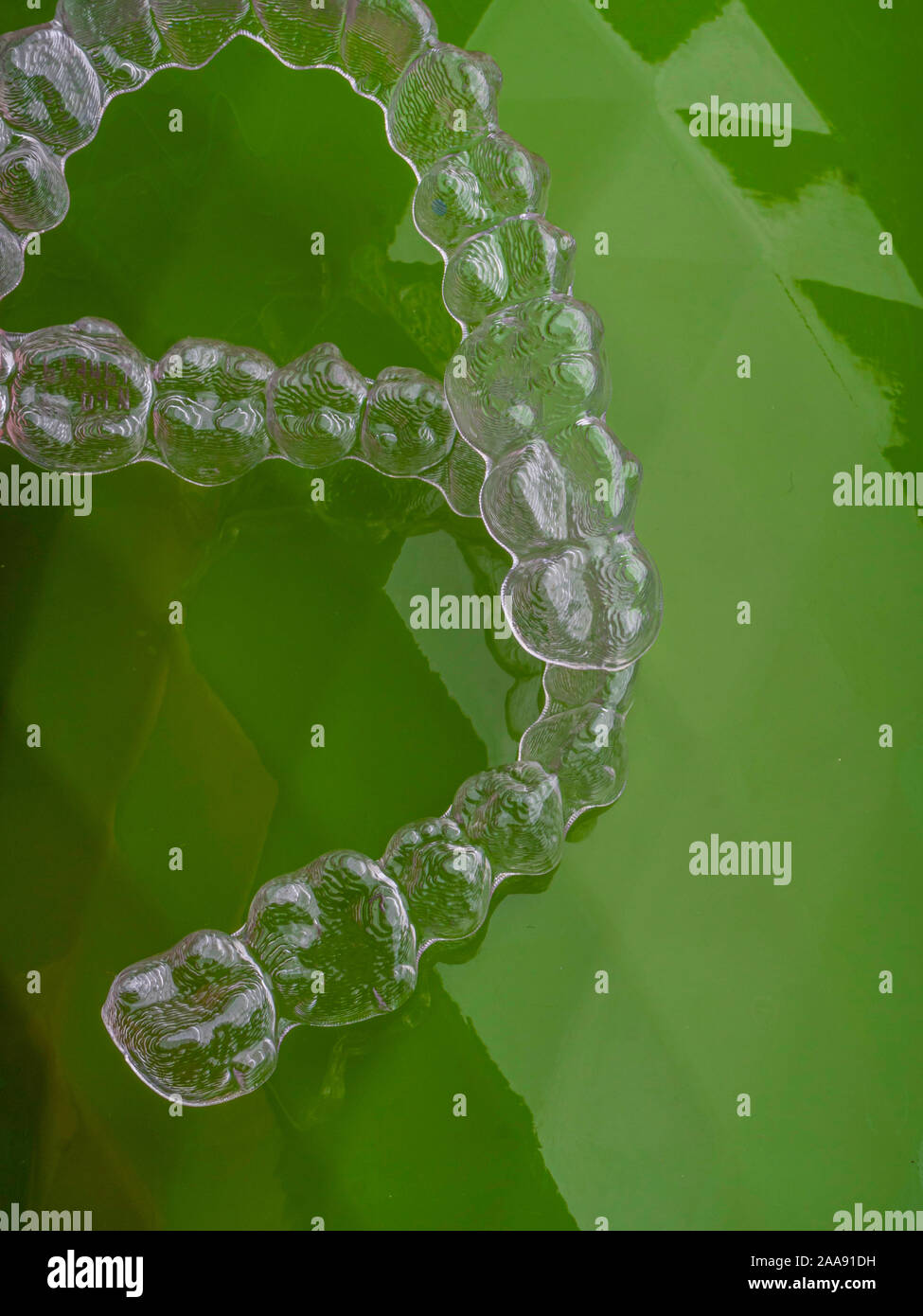 Teeth orthodontic clear aligner to straighten teeth on green surface ...