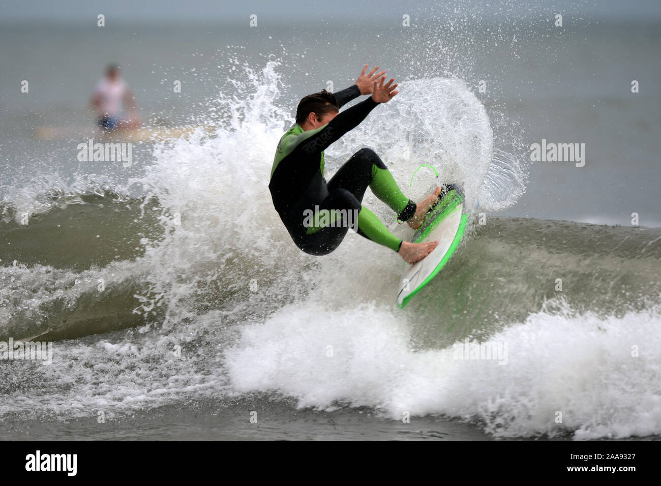 Surfer riding over the lip of a breaking wave in a 'floater'. Friend ...