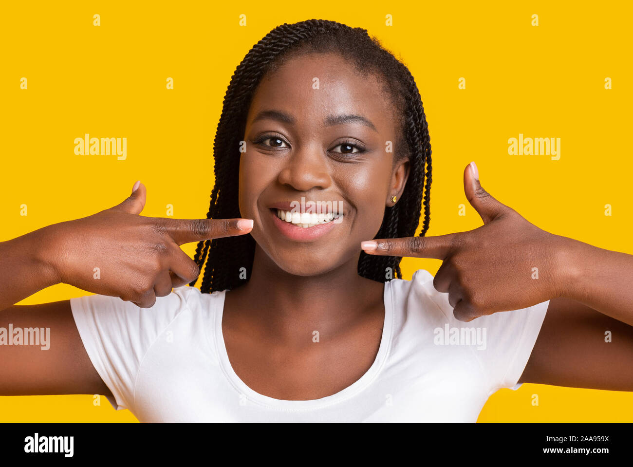 Close up of smiling girl pointing at her white teeth Stock Photo - Alamy