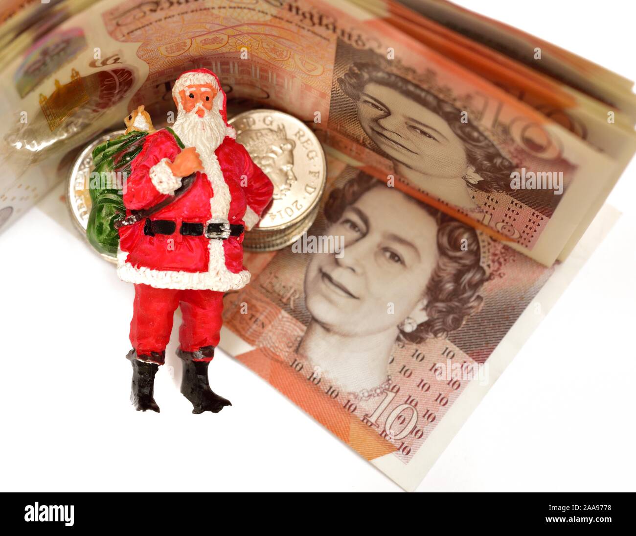 A santa claus figurine standing in front of some new ten pound notes ...